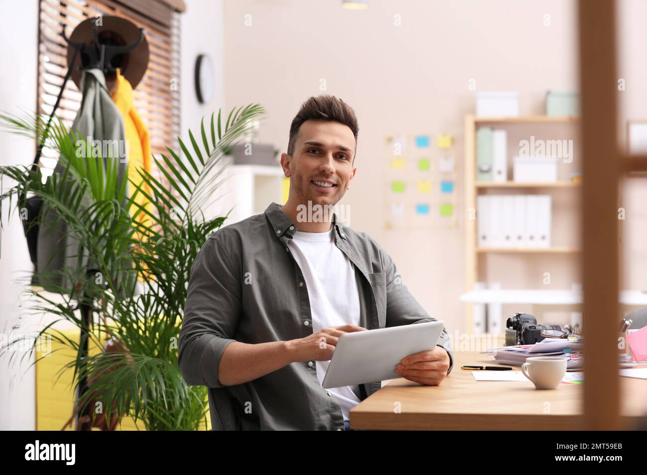 Journalist with tablet at workplace in office Stock Photo - Alamy