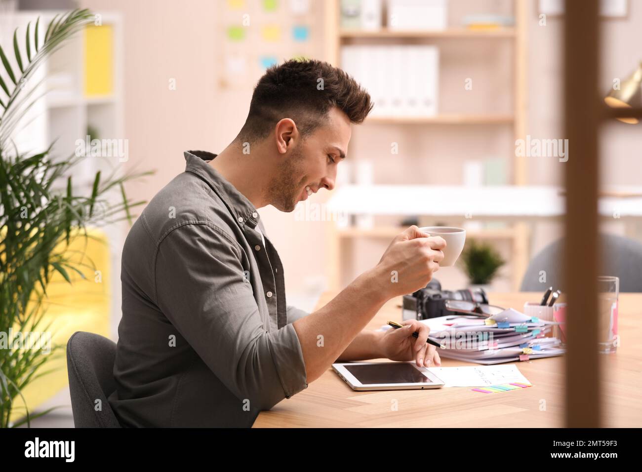 Journalist with tablet and coffee at workplace in office Stock Photo ...