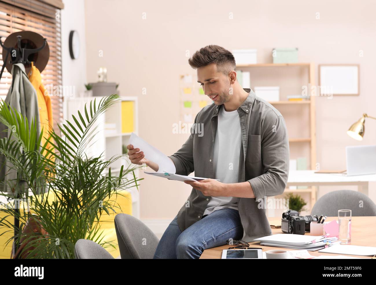 Journalist with papers at workplace in office Stock Photo - Alamy
