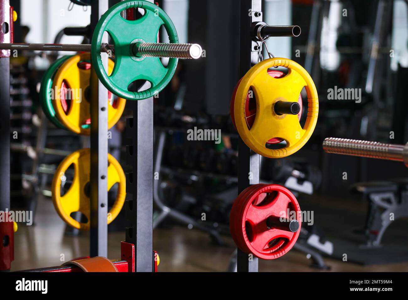 Barbell weight plates on rack in gym Stock Photo - Alamy