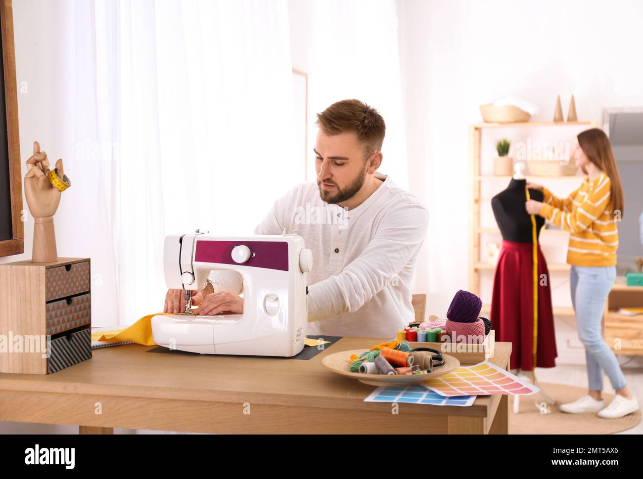 Fashion designer sewing new clothes with machine in studio Stock Photo ...
