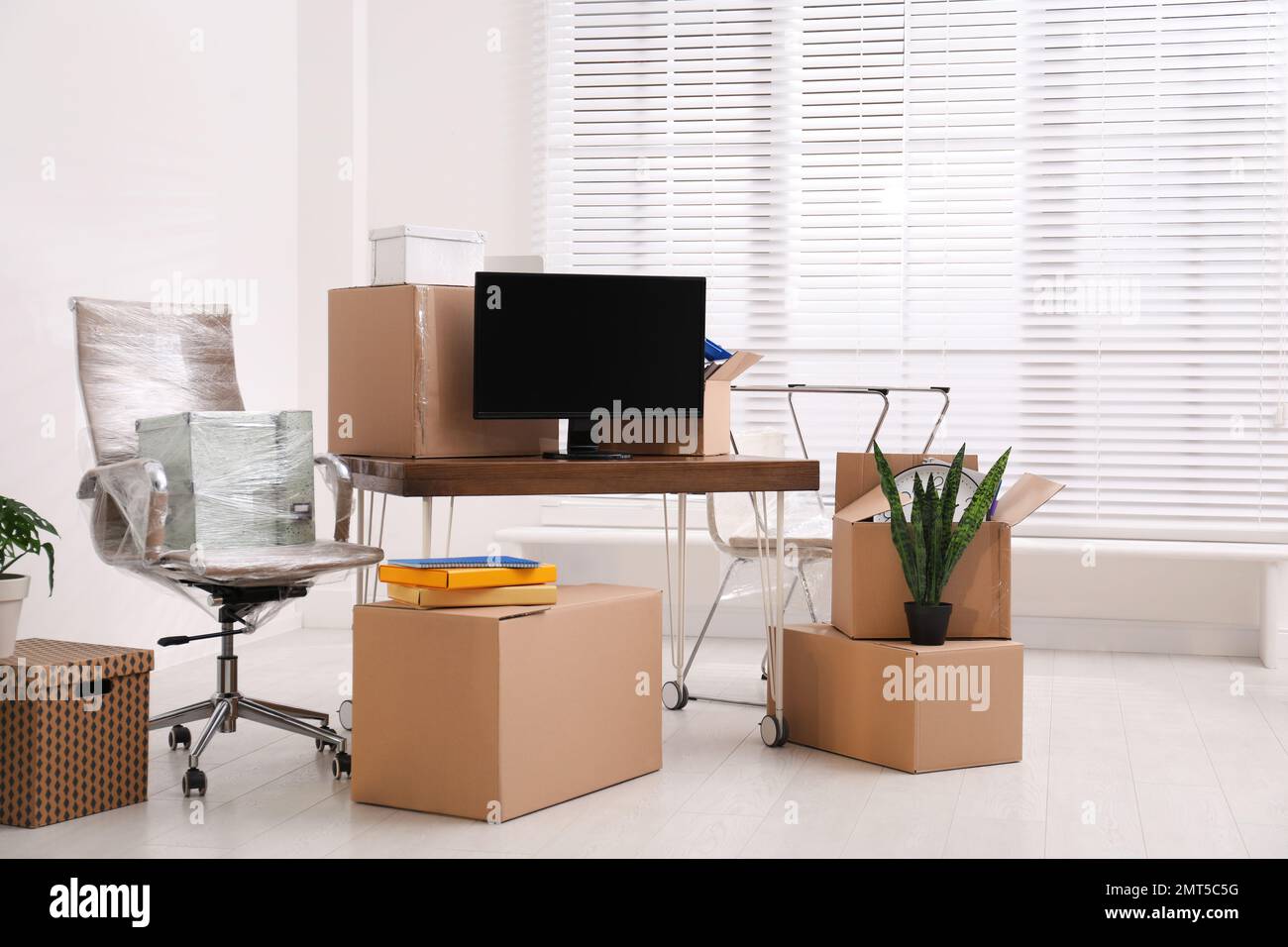 Cardboard boxes and packed belongings in office. Moving day Stock Photo ...