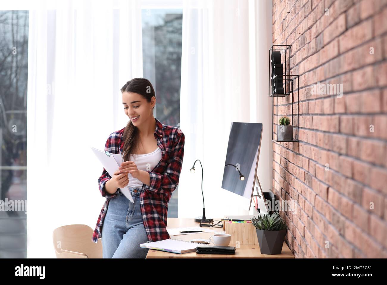 Professional journalist with papers at workplace in light office Stock ...