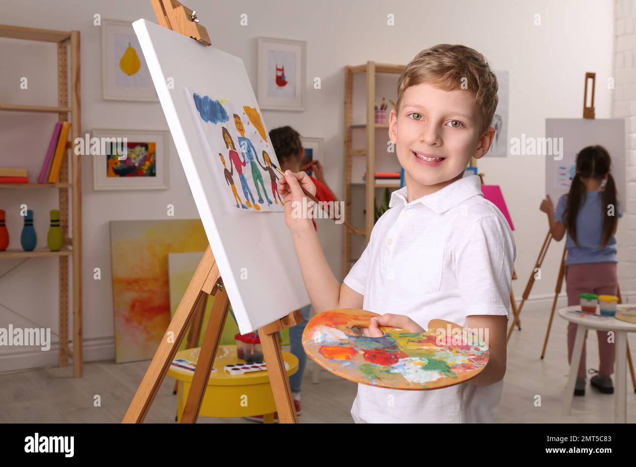 Cute little child painting during lesson in room Stock Photo - Alamy