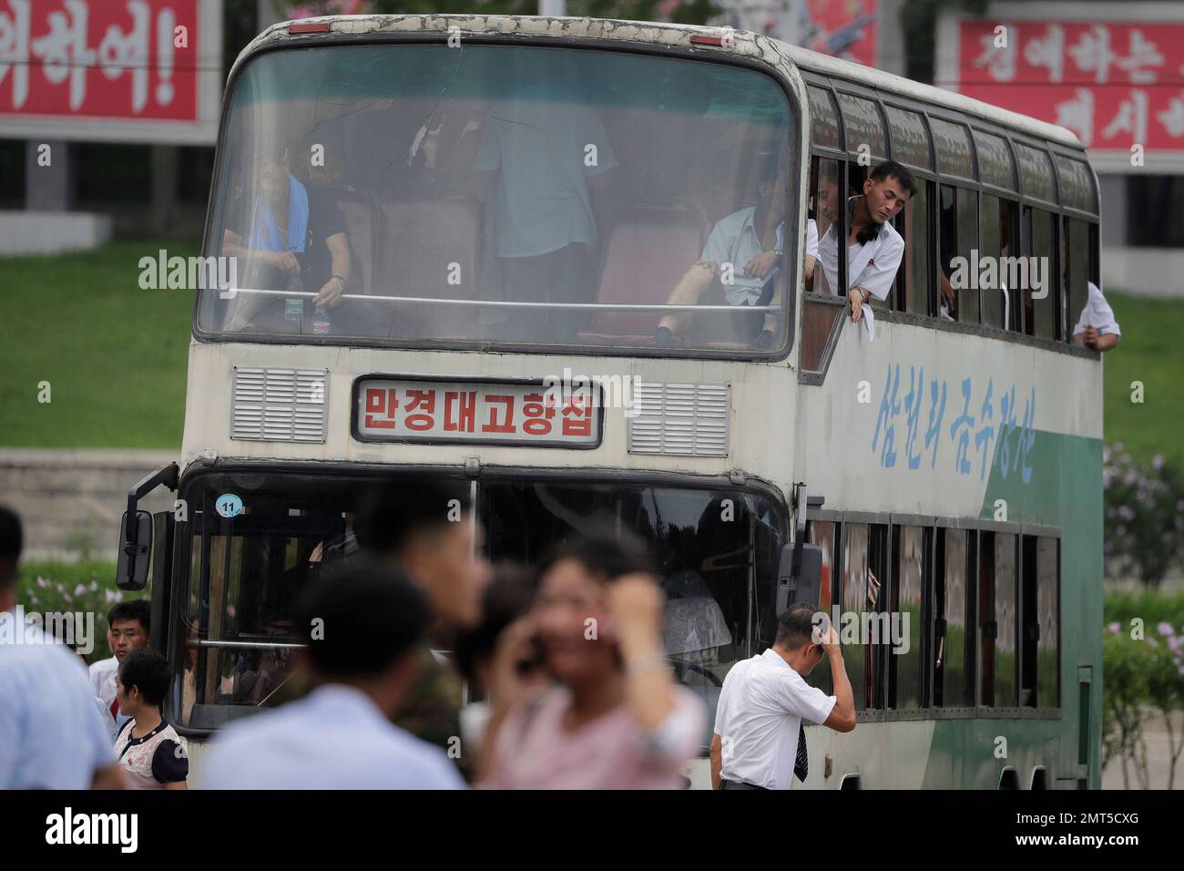 A man looks out the window of a double decker bus at the end of a work ...