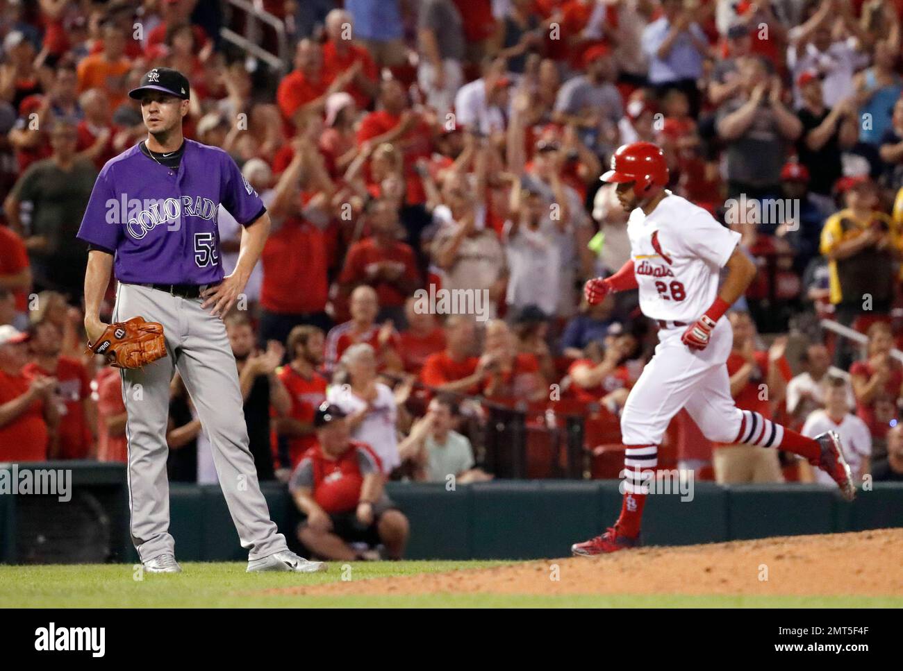 Colorado Rockies relief pitcher Chris Rusin, left, pauses as St. Louis ...