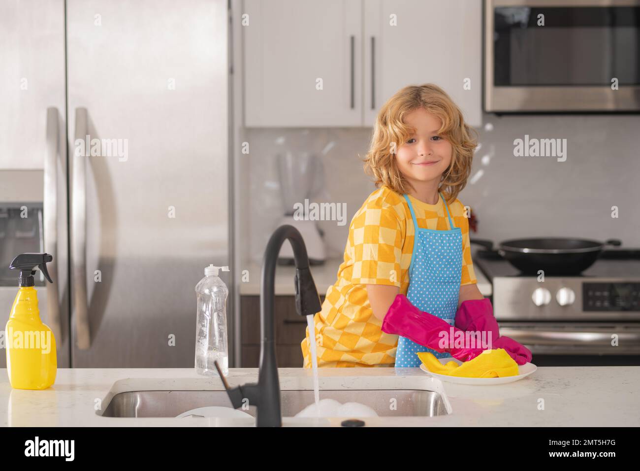 Cute child helping with household, wiping dishes in kitchen. Adorable ...