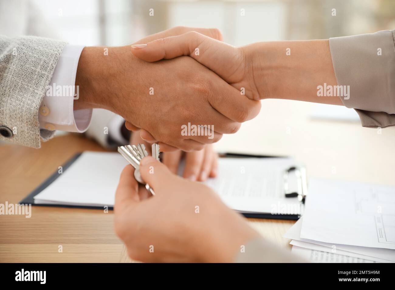 Real estate agent shaking hands with client in office, closeup Stock ...