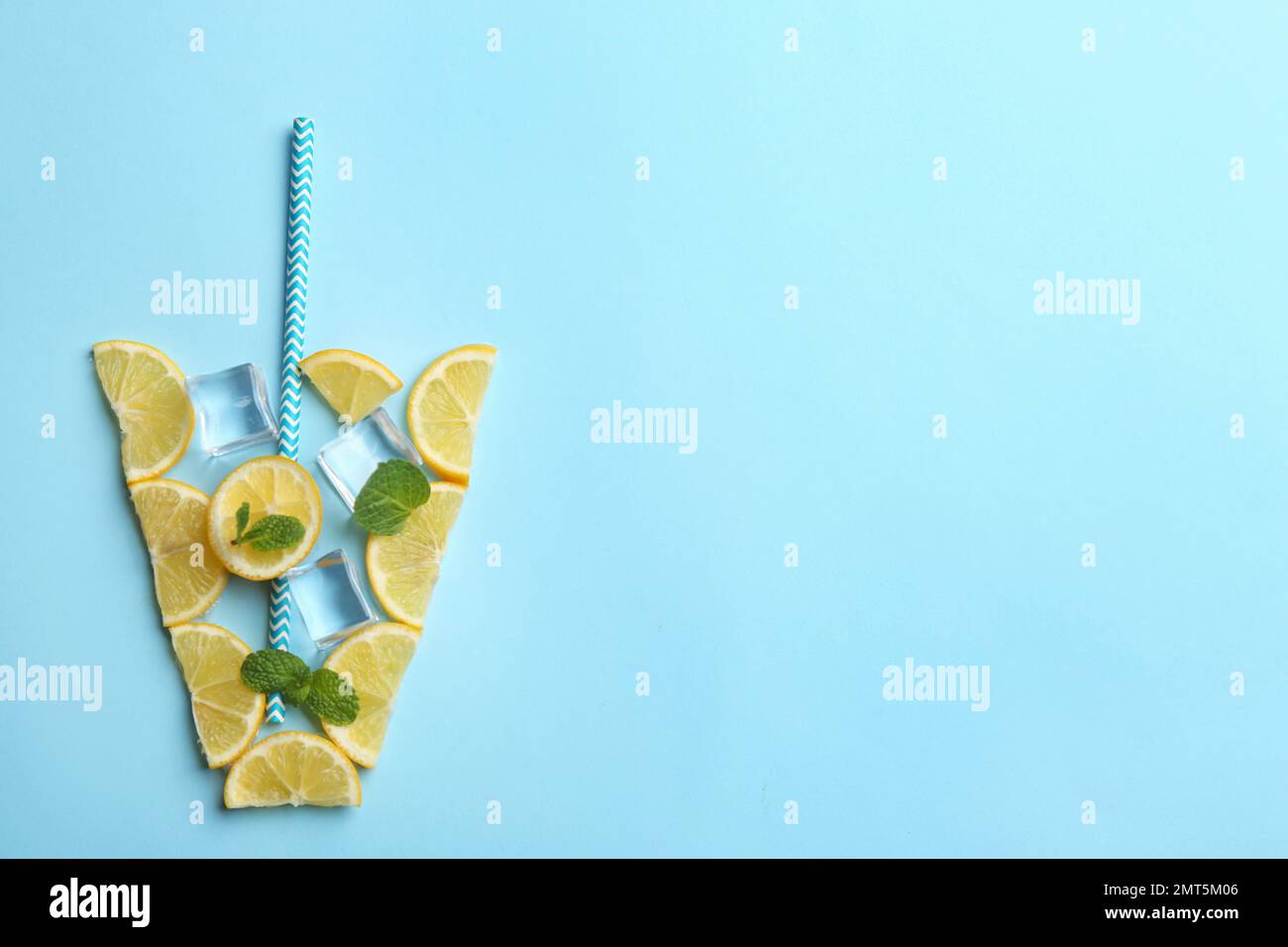 Creative lemonade layout with lemon slices, mint and ice on light blue ...
