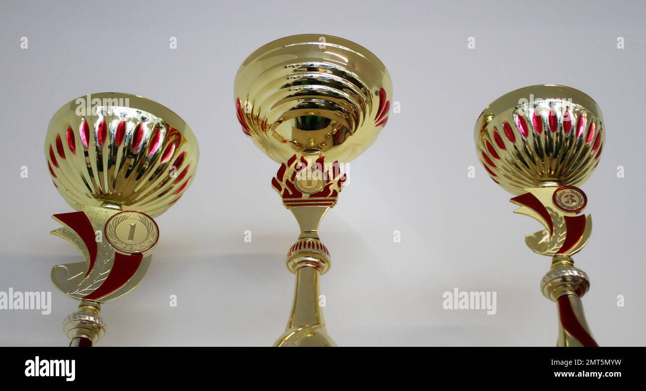 Golden sports cups for winning competitions on a shelf Stock Photo - Alamy