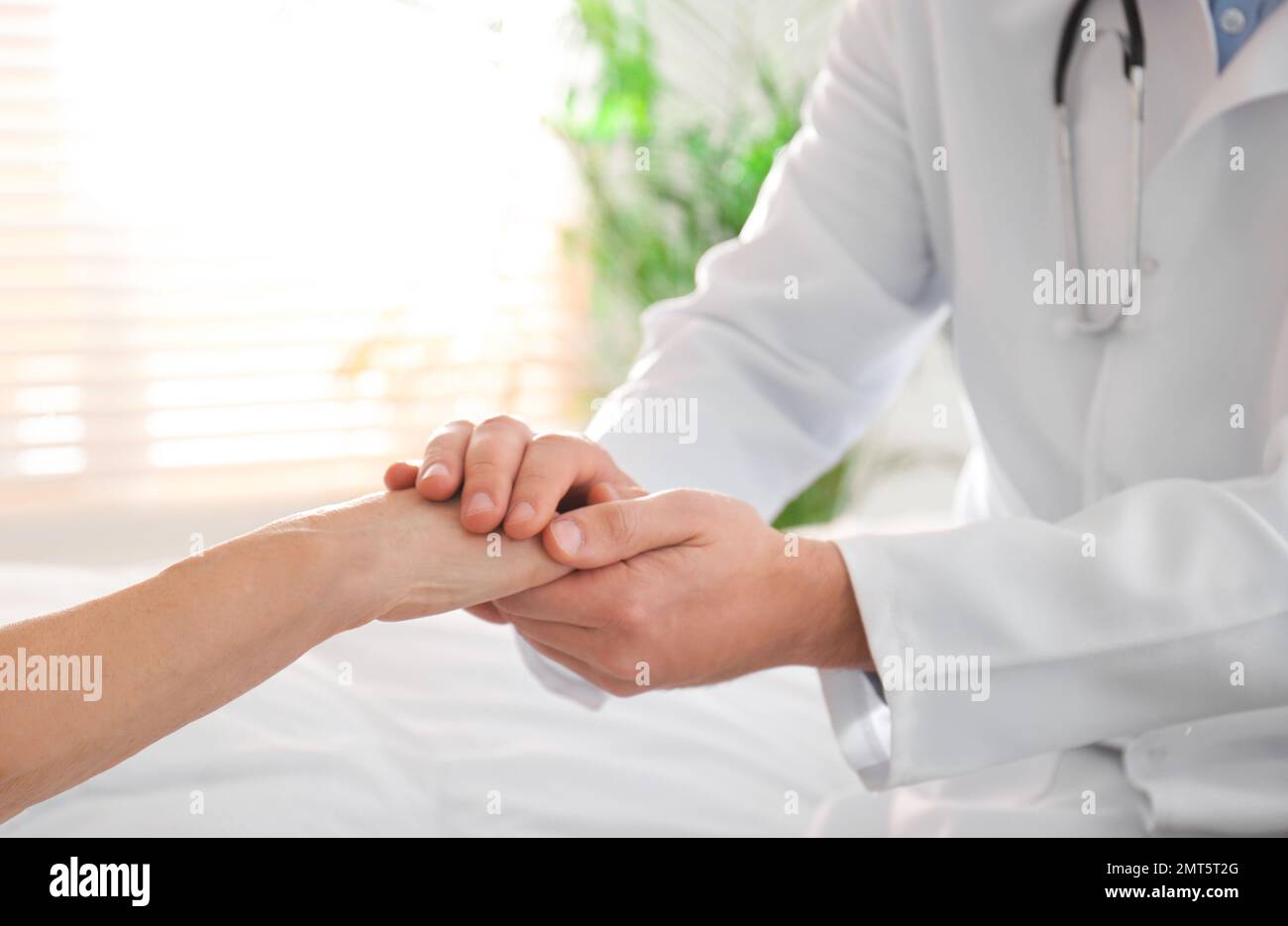 Doctor and senior patient holding hands in hospital, closeup Stock ...