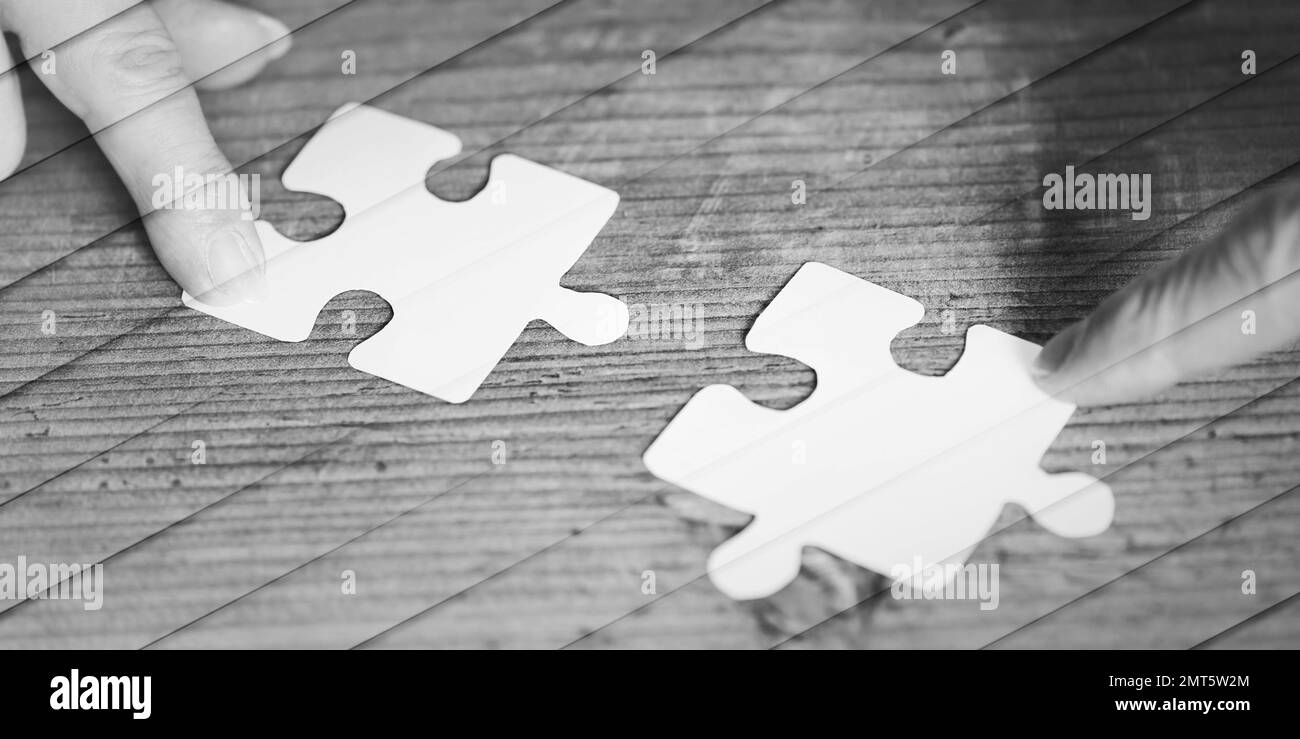 Hands joining two puzzle pieces, teamwork concept, geometric pattern ...