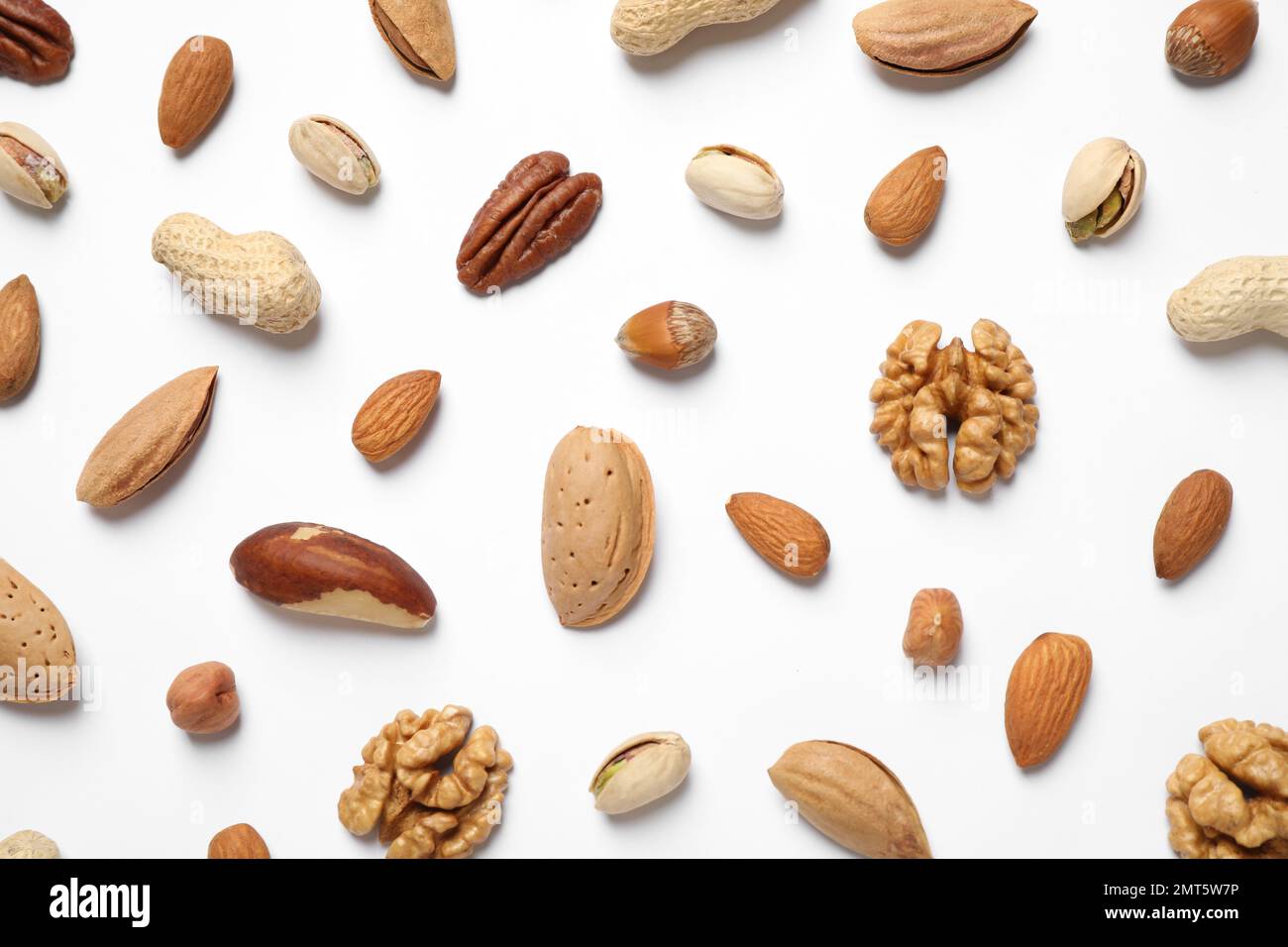 Different delicious nuts on white background, flat lay Stock Photo - Alamy