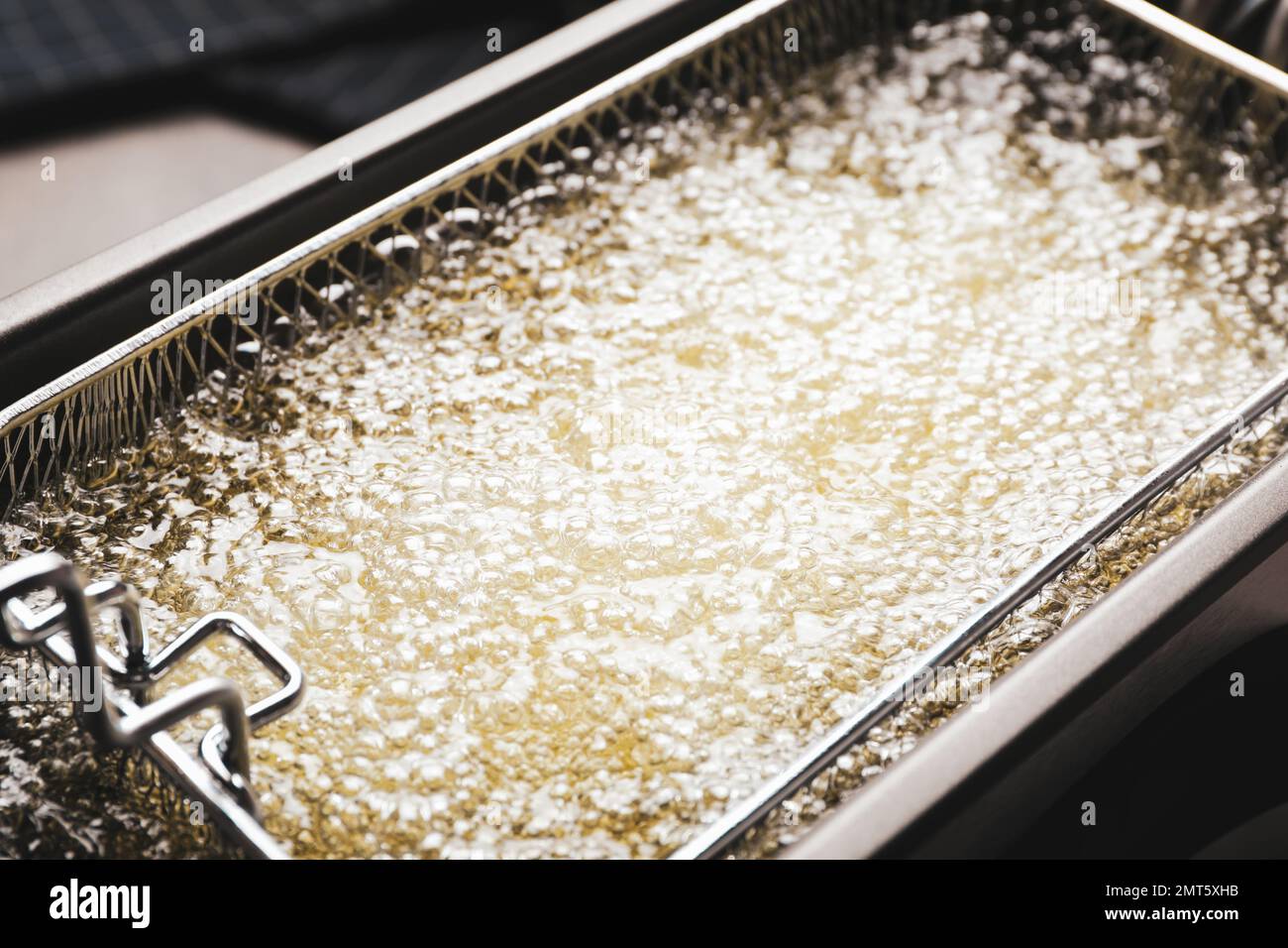 Cooking delicious french fries in hot oil, closeup Stock Photo - Alamy