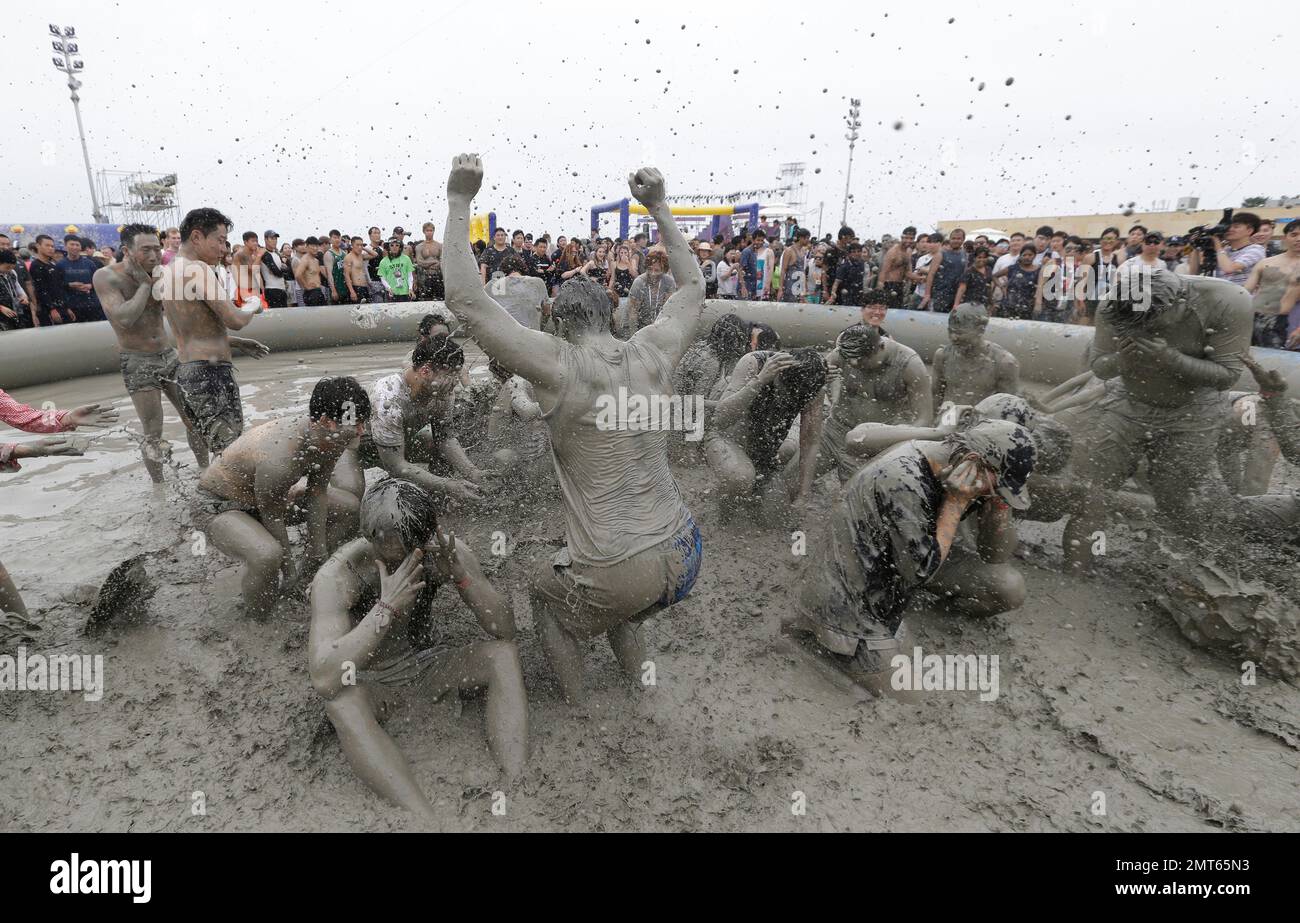 People play in a mud pool during the Boryeong Mud Festival at Daecheon ...