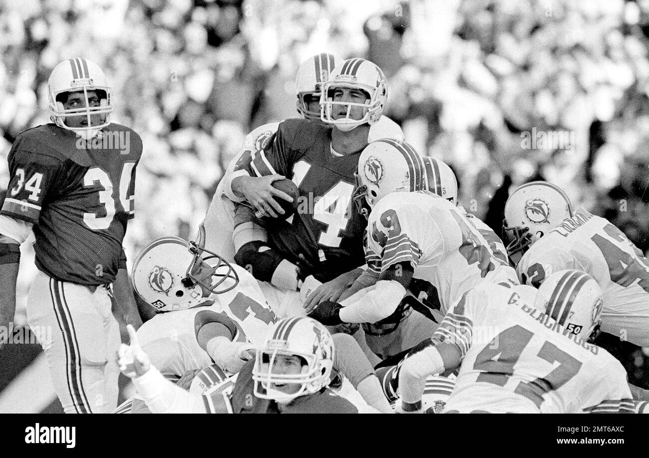 New England Patriots quarterback Steve Grogan (14) is uprighted as he ...