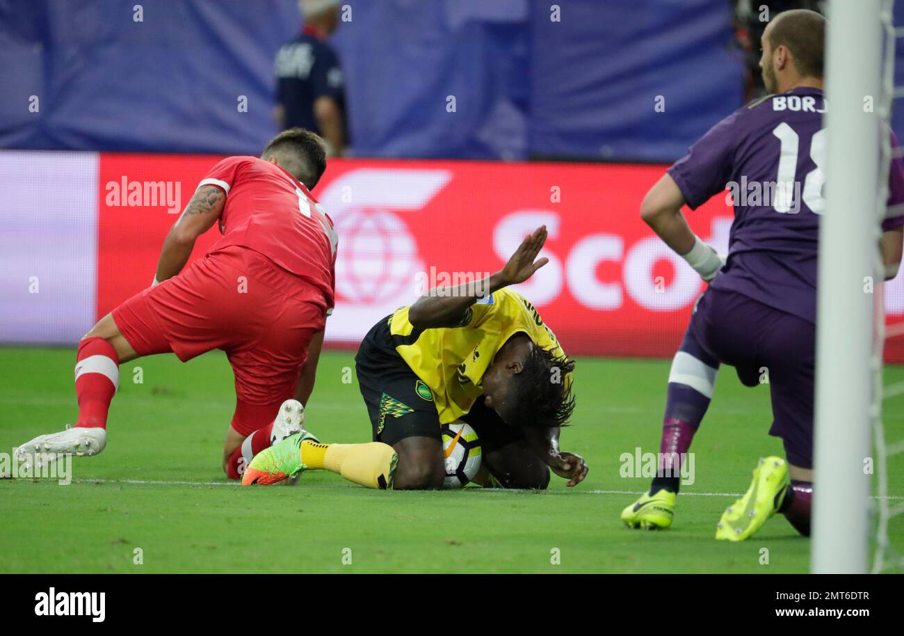 Canada's Steven Vitoria, left, gets of the pitch after stopping Jamaica ...