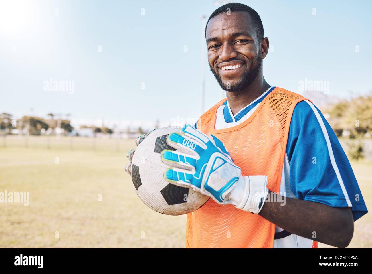 Soccer, goal keeper and portrait of black man with ball and smile on ...