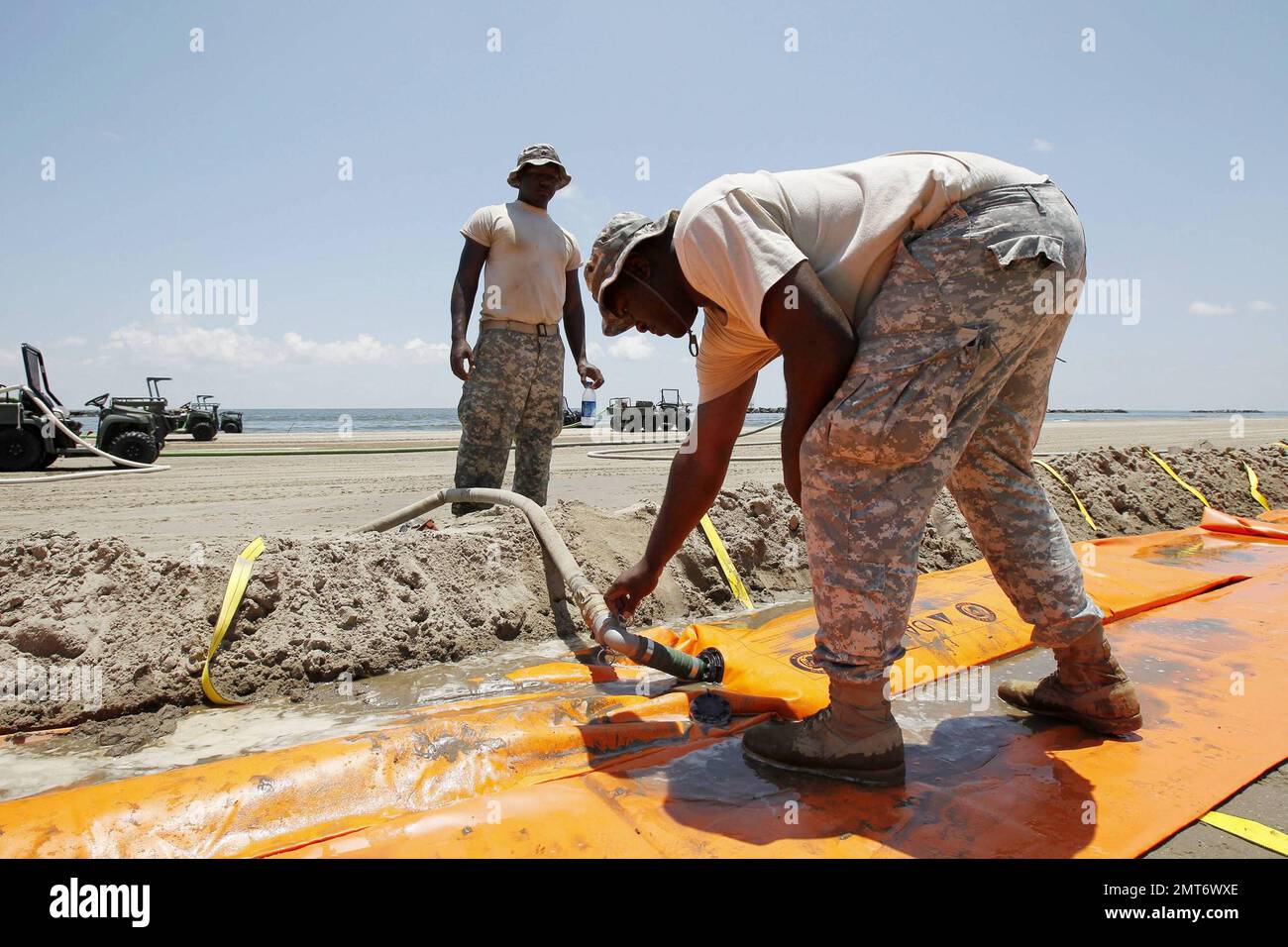 Inflatable barricades are installed by the National Guard on the beach ...