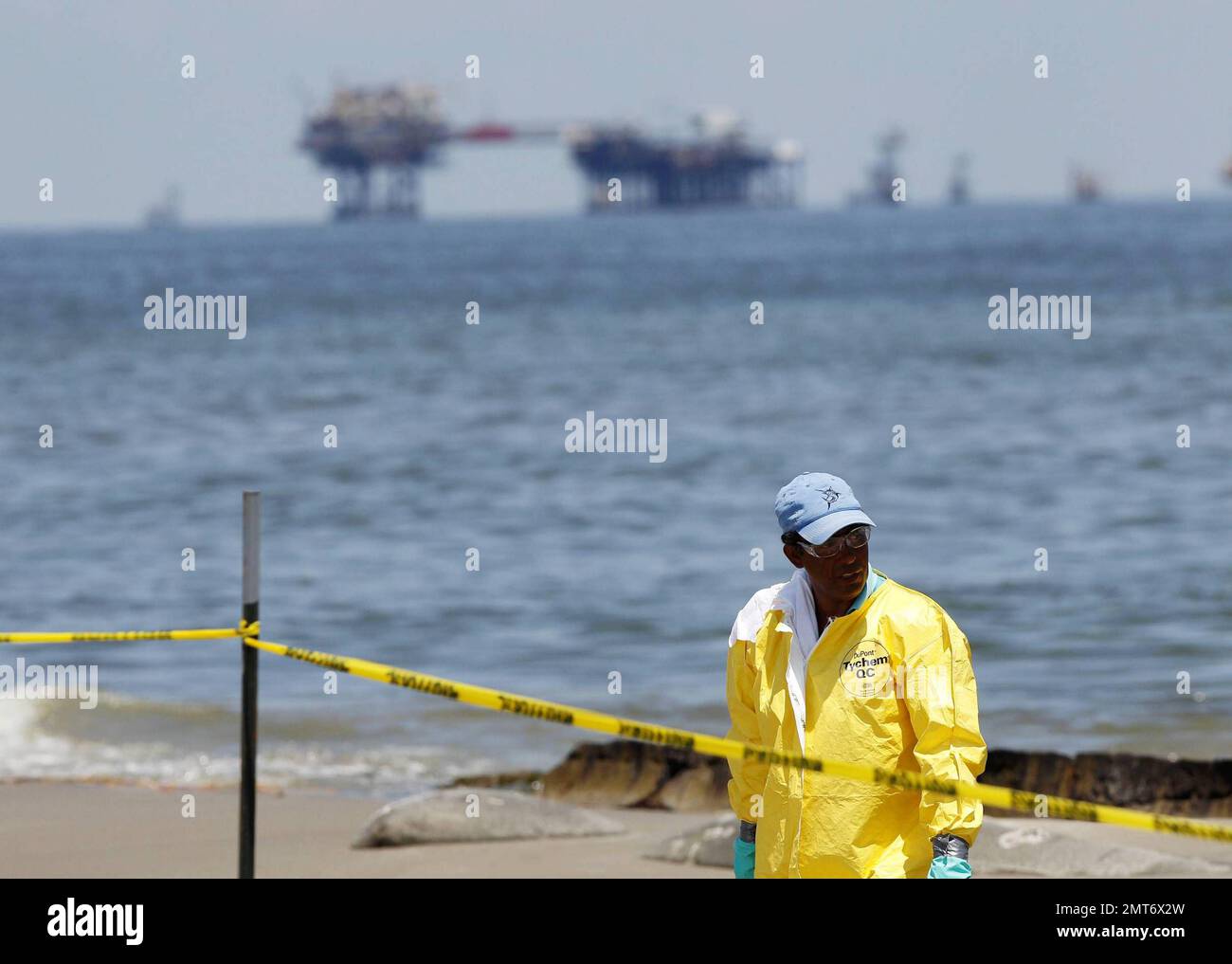 Workers clean up contaminated parts of the beach to remove oil in Grand ...