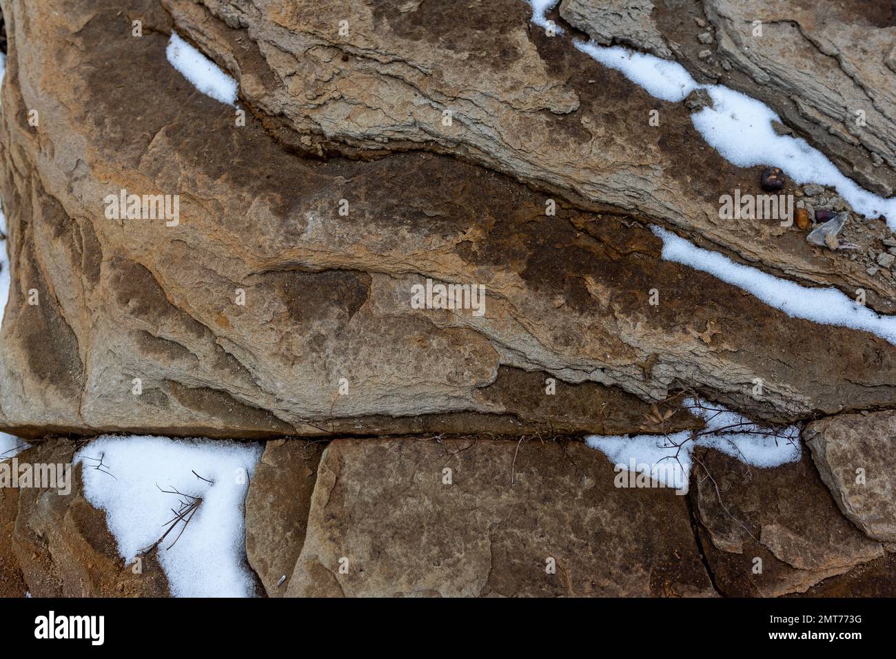 Photo of a stone granite rock with snow lying on it. Natural texture ...