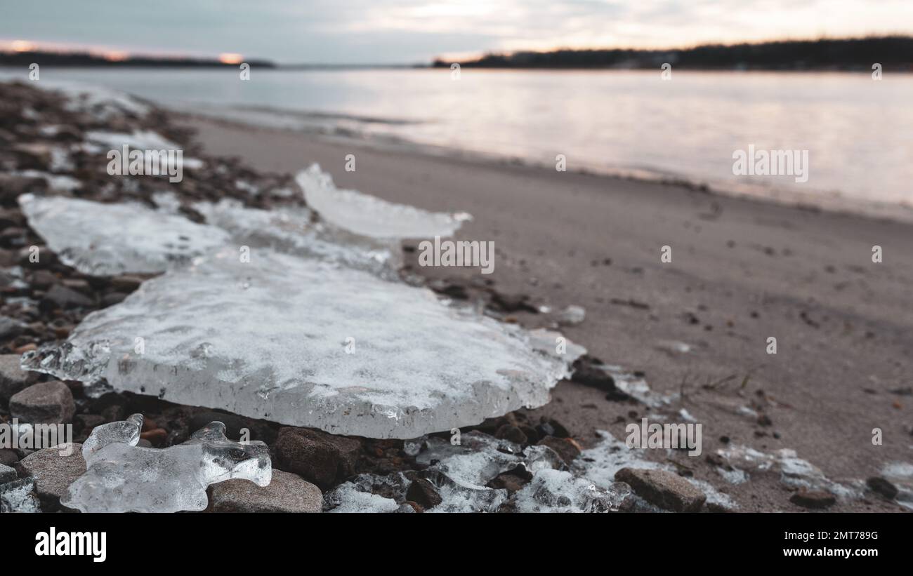 Small glaciers of the first ice lie on the sandy bank of the Vilyui ...