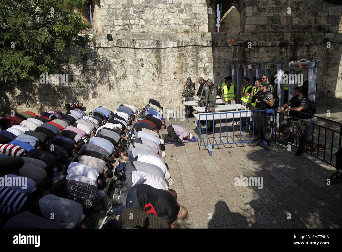 Israeli border police officers stand guard as Muslim men pray outside ...
