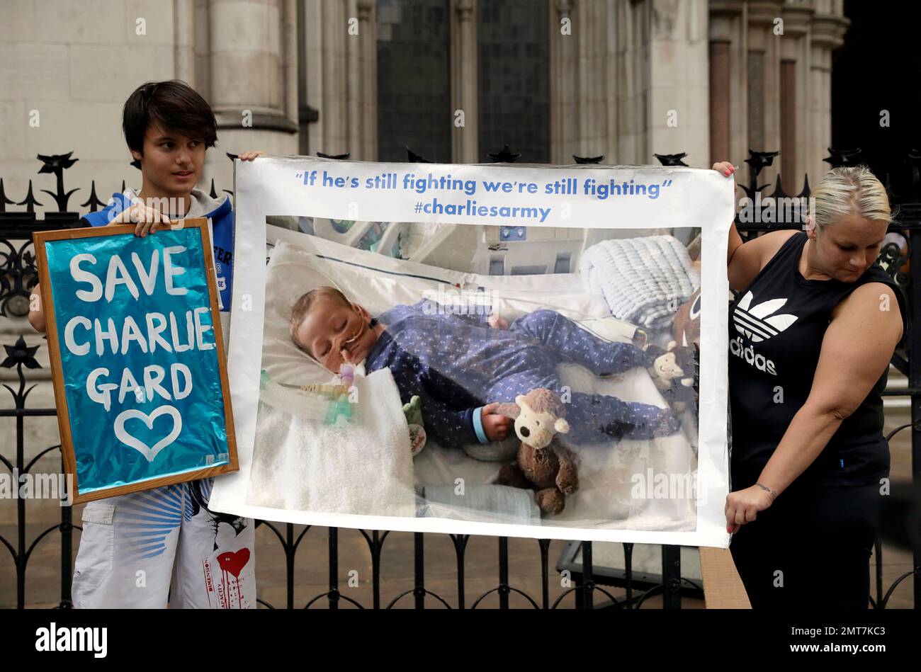 Supporters of critically ill baby Charlie Gard hold up a photograph of ...