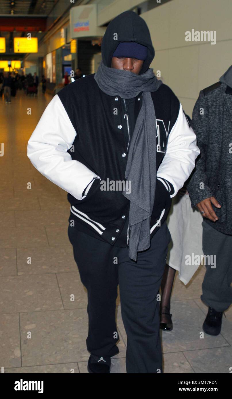 Sean "P Diddy" Combs covers up with a black hoodie, blue hat and grey ...