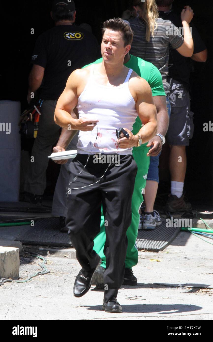 Mark Wahlberg shows off his bulky physique in a white tank top as he ...