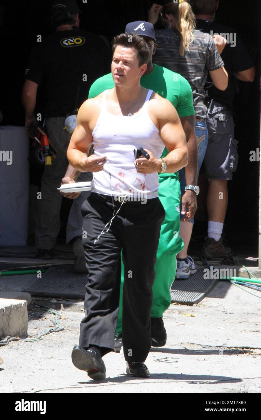 Mark Wahlberg shows off his bulky physique in a white tank top as he ...