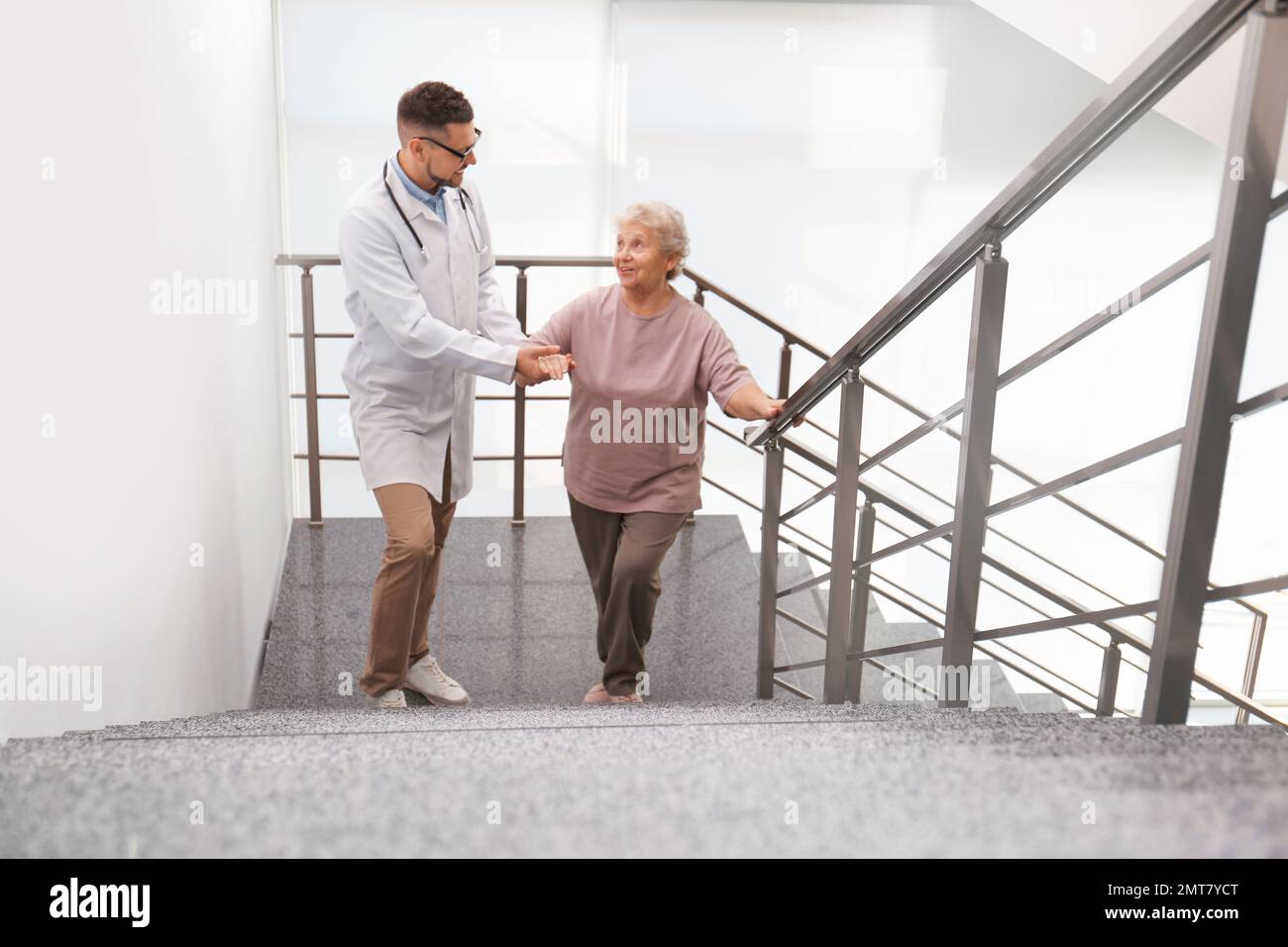 Doctor helping senior patient in modern hospital Stock Photo - Alamy