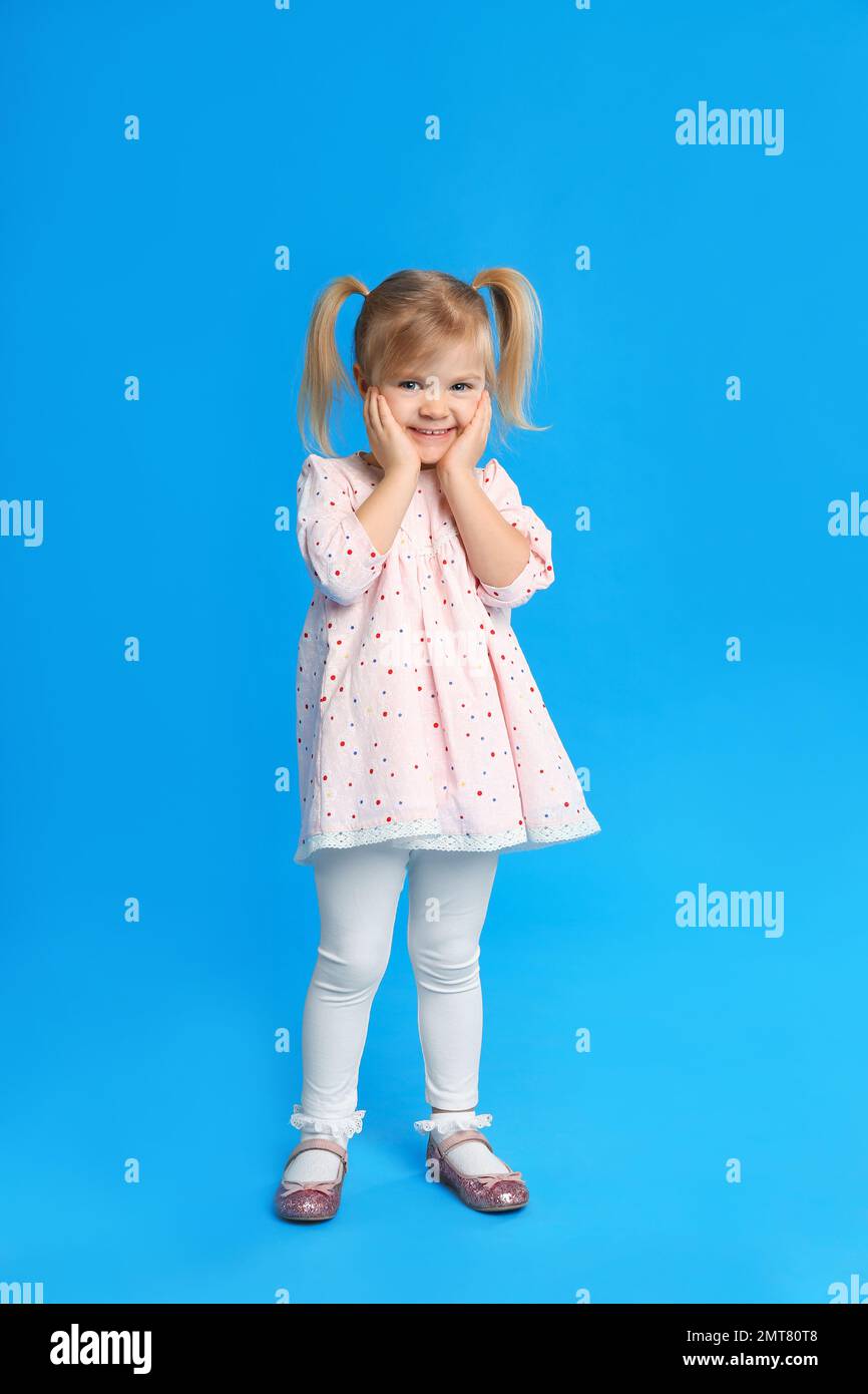 Portrait of cute little girl on blue background Stock Photo - Alamy
