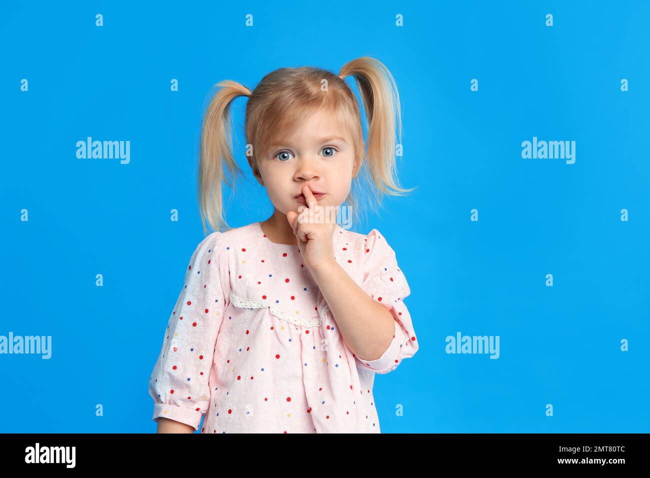 Portrait of cute little girl on blue background Stock Photo - Alamy