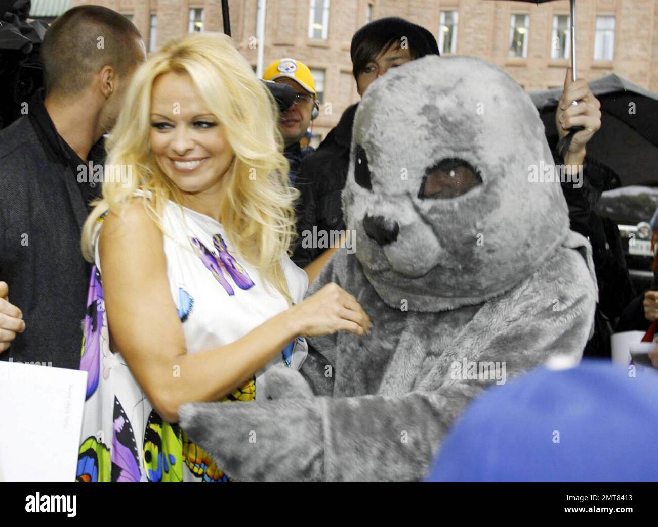 Pamela Anderson wears a colorful spring-like dress on a very dreary day ...
