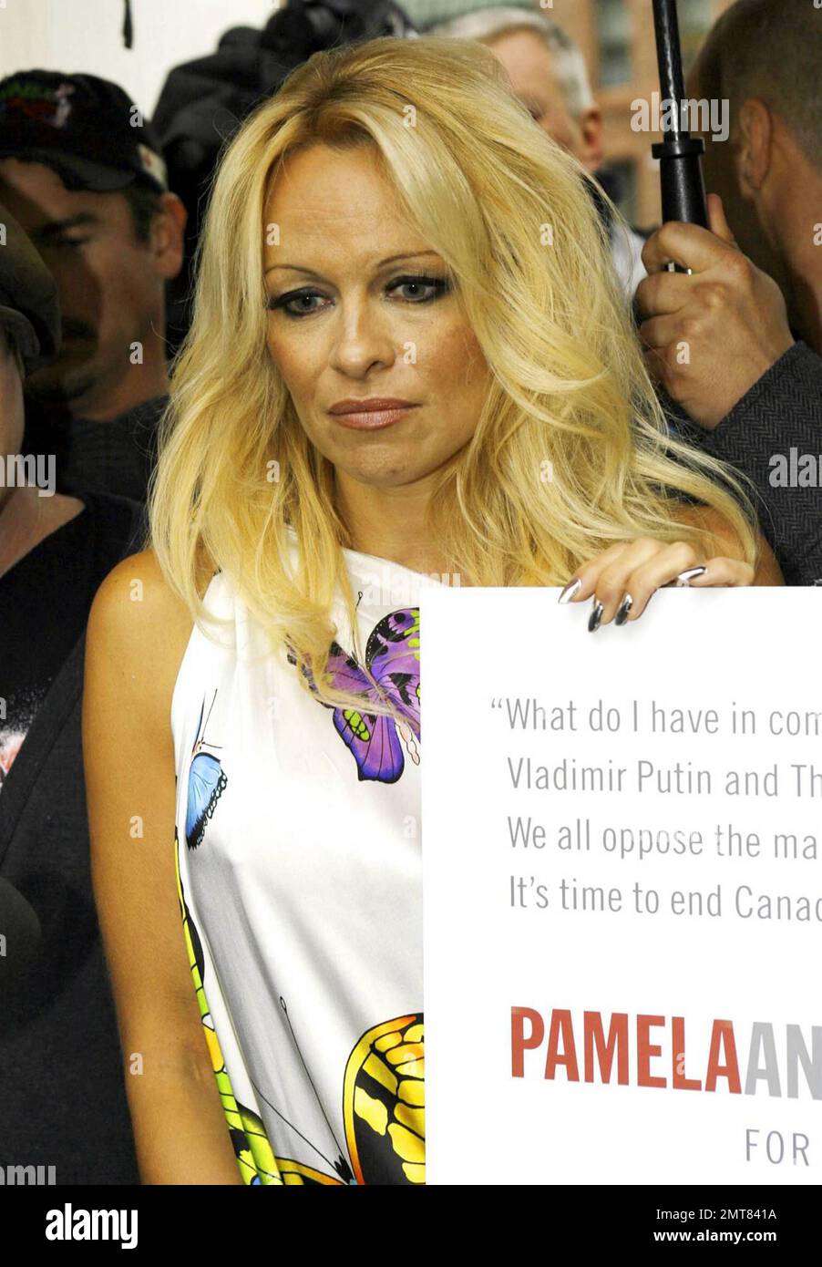 Pamela Anderson wears a colorful spring-like dress on a very dreary day ...