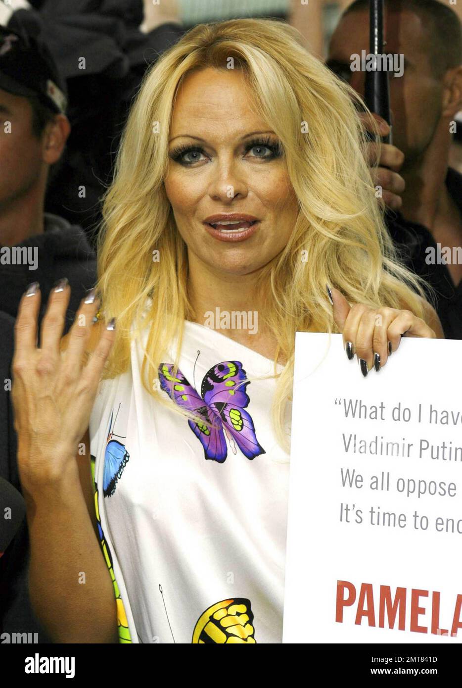 Pamela Anderson wears a colorful spring-like dress on a very dreary day ...