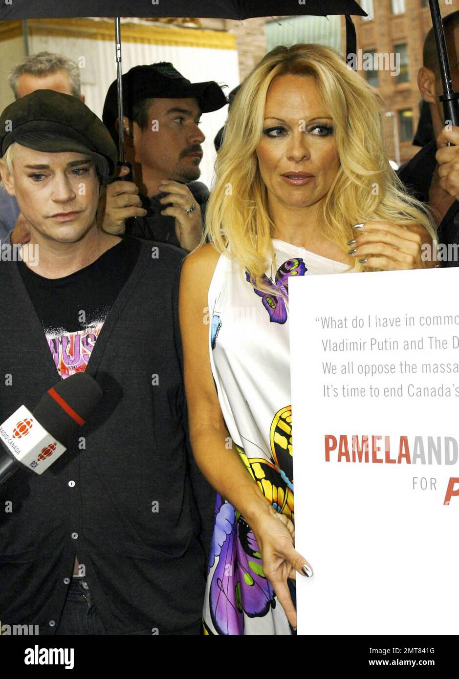 Pamela Anderson wears a colorful spring-like dress on a very dreary day ...