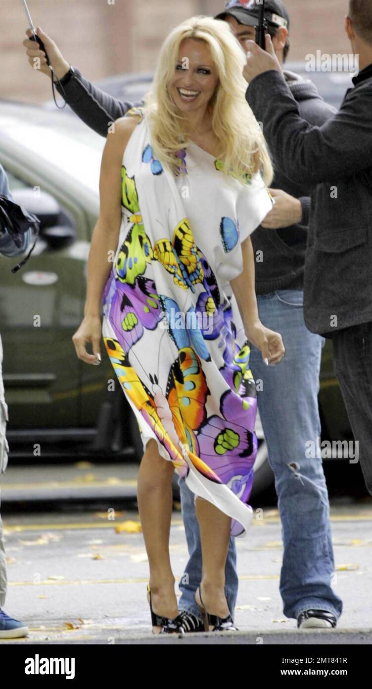 Pamela Anderson wears a colorful spring-like dress on a very dreary day ...