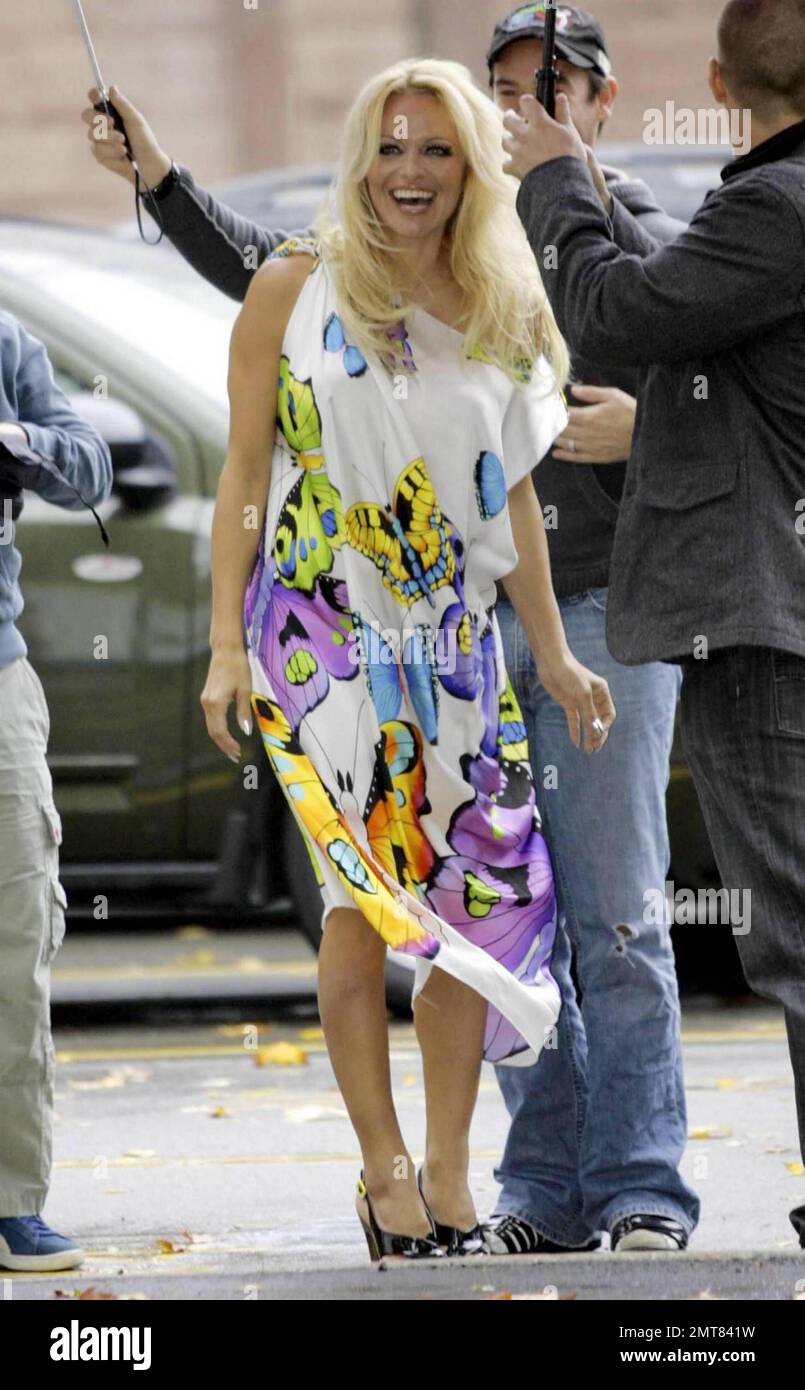 Pamela Anderson wears a colorful spring-like dress on a very dreary day ...