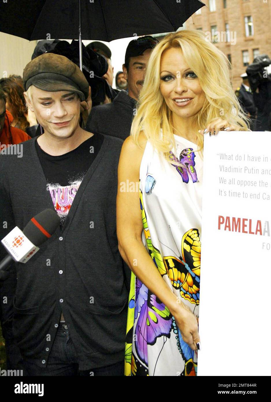 Pamela Anderson wears a colorful spring-like dress on a very dreary day ...