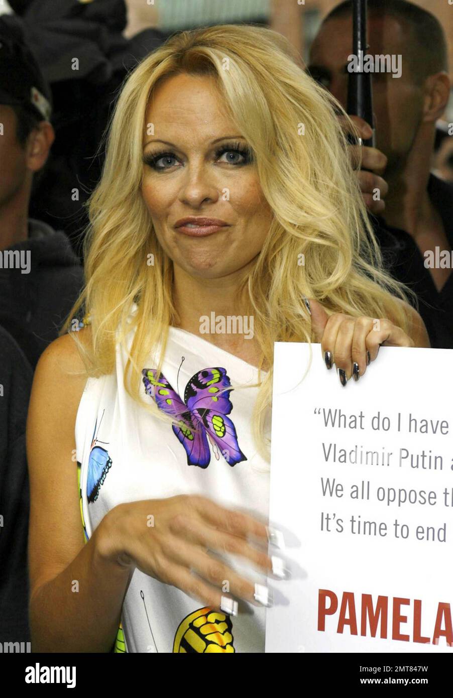 Pamela Anderson wears a colorful spring-like dress on a very dreary day ...