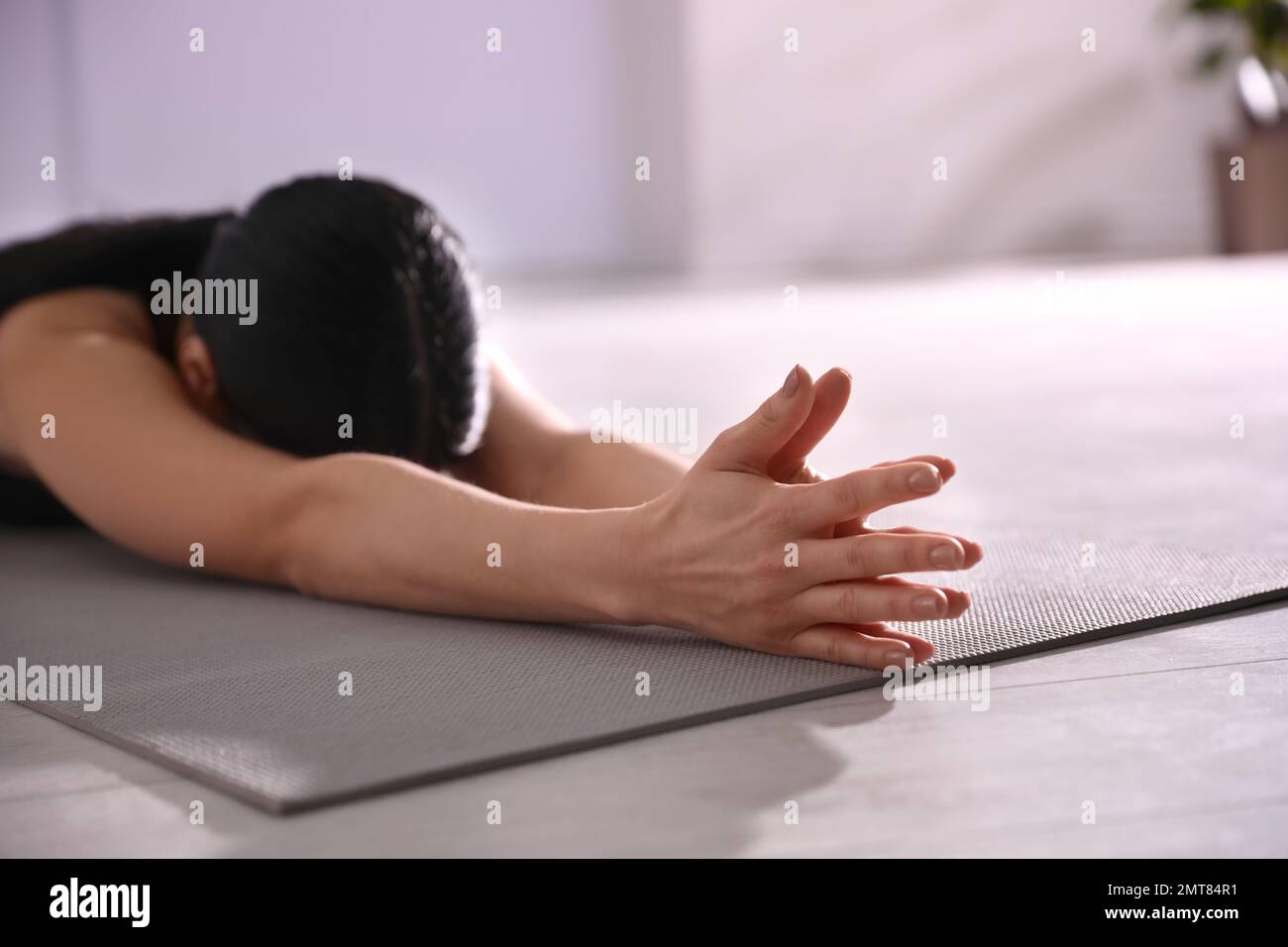 Young woman practicing extended child's asana in yoga studio, closeup ...