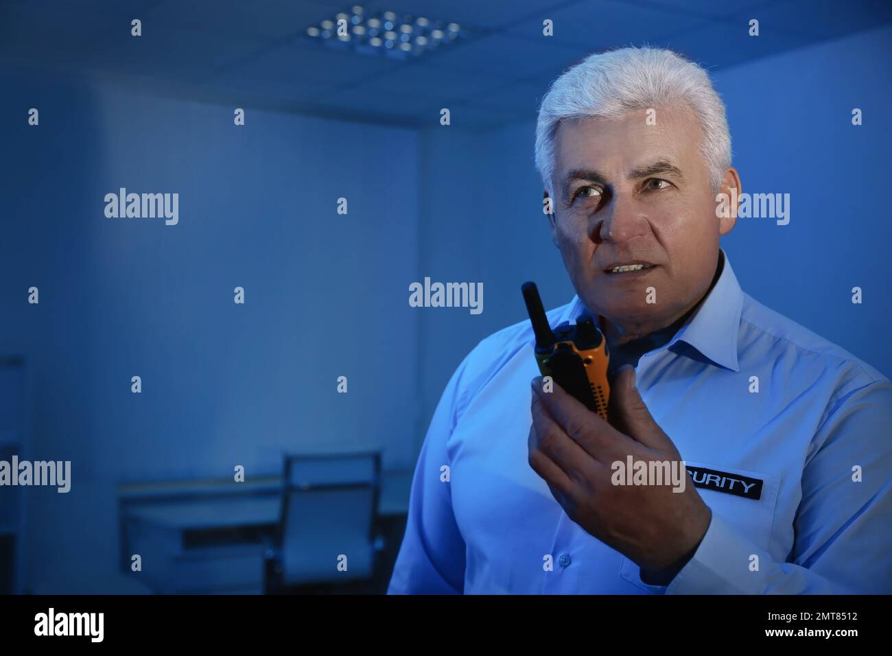 Professional security guard with portable radio set in dark room Stock ...