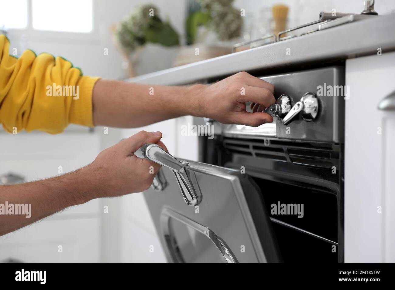 Man using modern oven in kitchen, closeup Stock Photo - Alamy