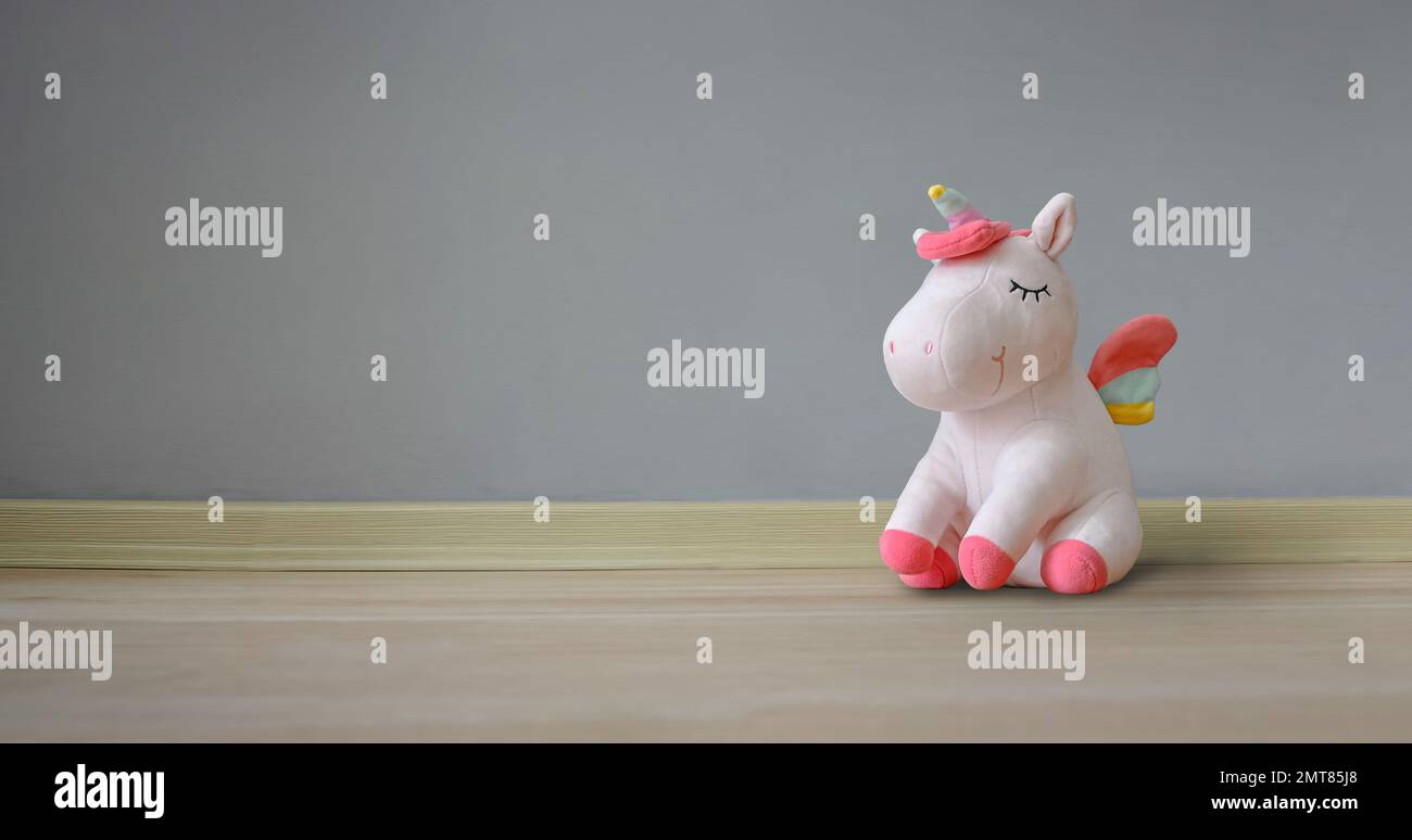 Cute soft unicorn plush toy on the floor. Close up shot, empty space ...