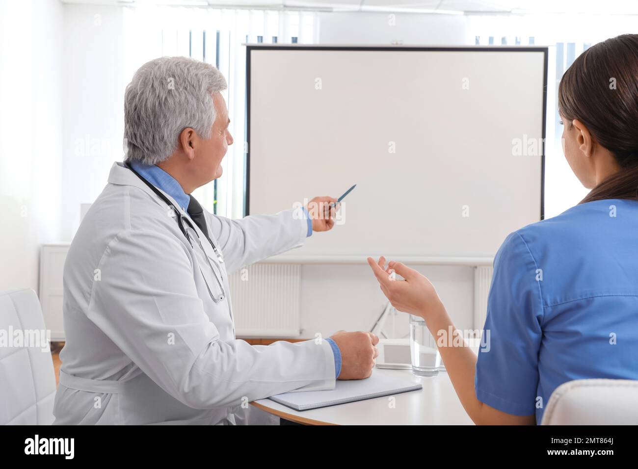 Team of doctors looking at projection screen indoors Stock Photo - Alamy