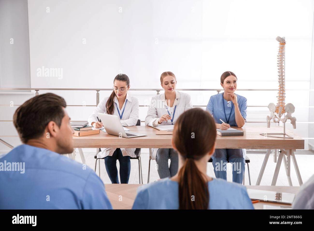 Medical students studying human spine structure in classroom Stock ...