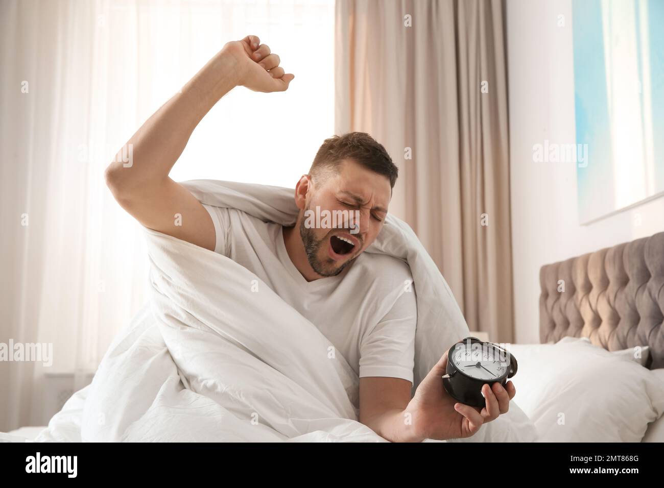 Man alarm clock stretching hi-res stock photography and images - Alamy