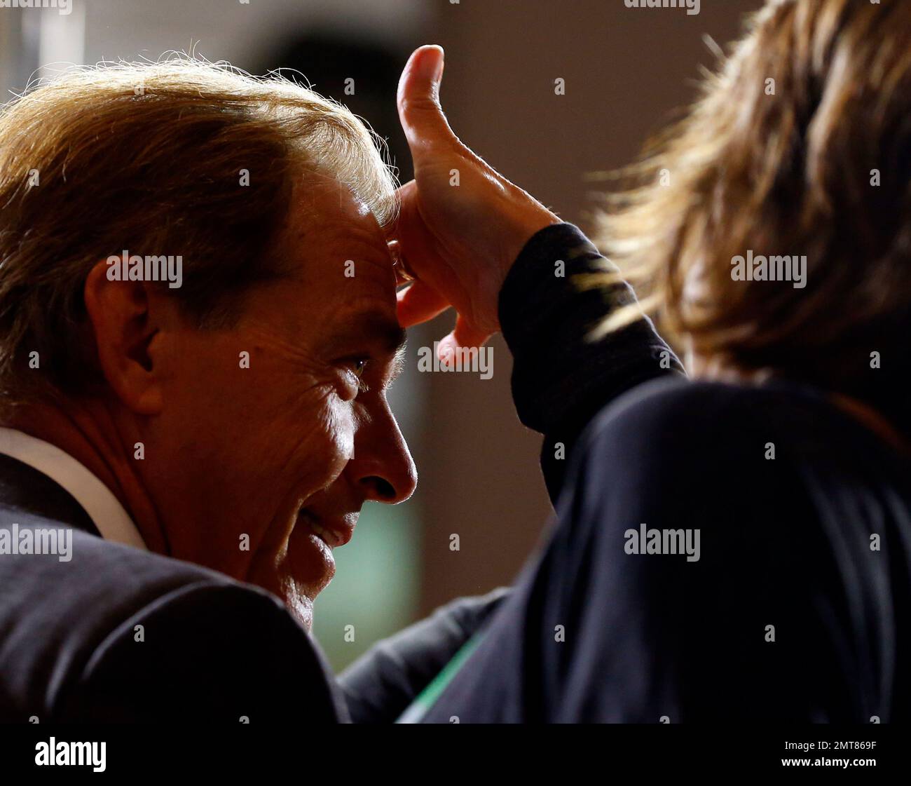A woman fixes Alabama NCAA college football coach Nick Saban's hair ...